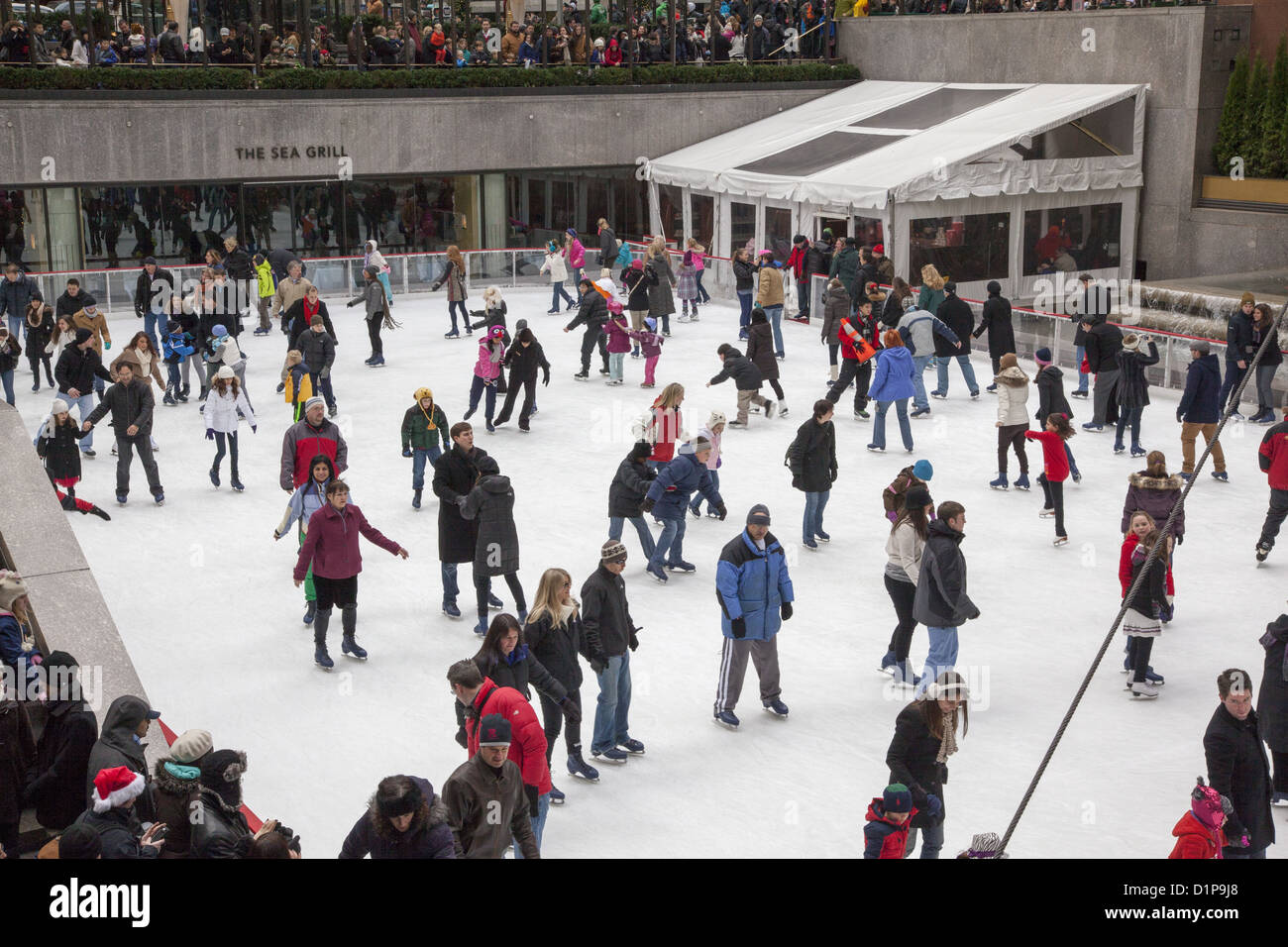 The skating rink and surroundings are packed with tourists and shoppers ...
