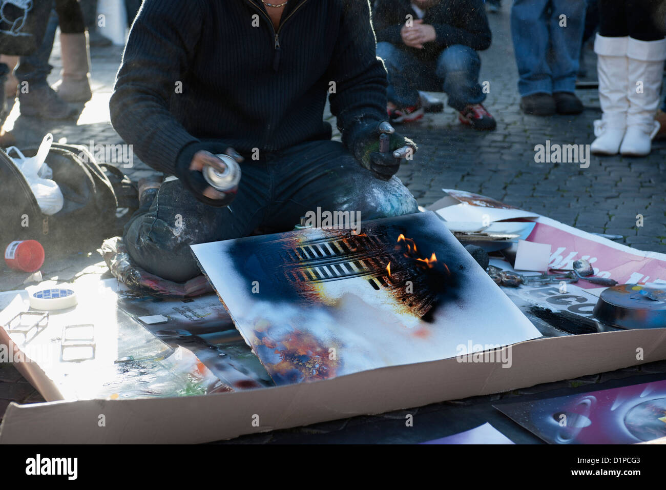 Street Artist paint and burn picture Stock Photo - Alamy