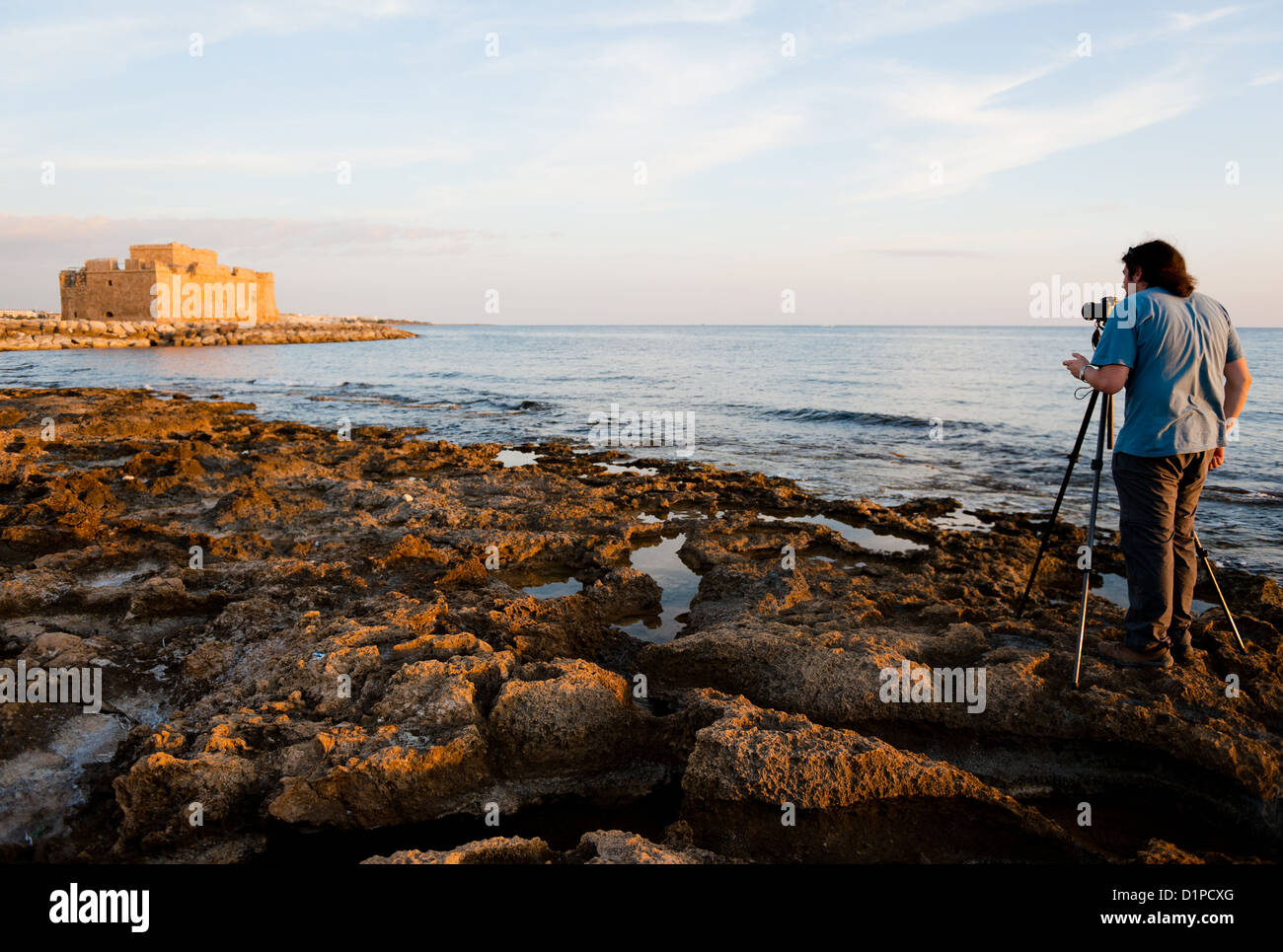 Young man photographing medieval castle at sunset, Paphos, Cyprus Stock ...