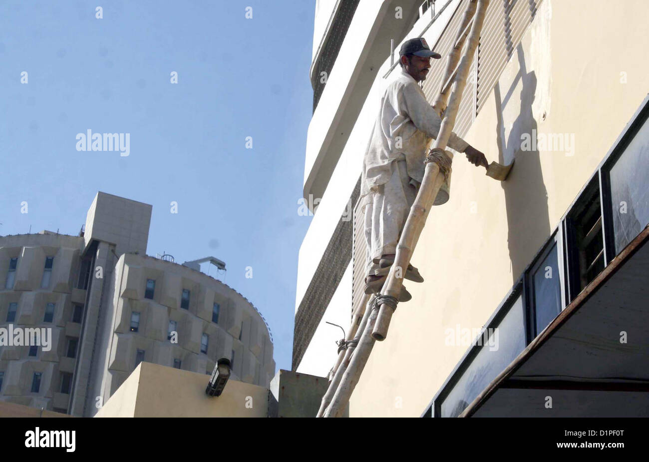 Laborer busy in paint on a building without any safety measures and put ...