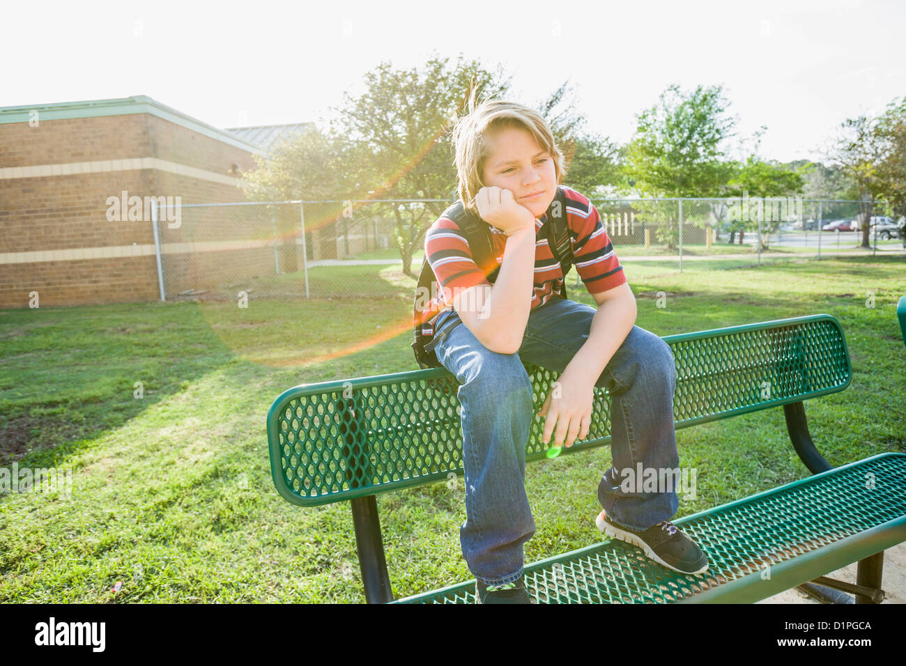 Caucasian boy sitting on bench Stock Photo - Alamy