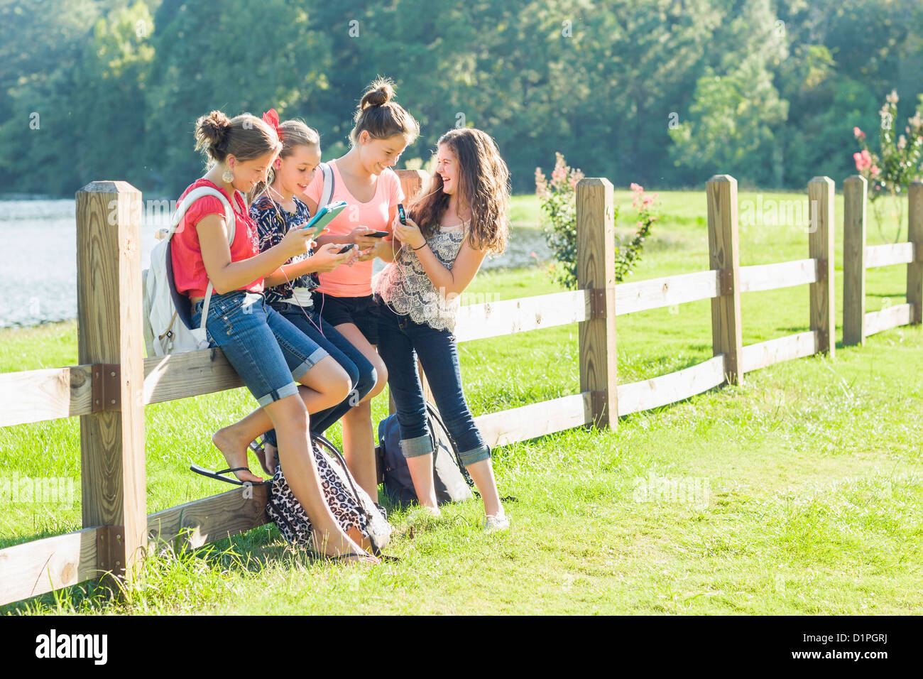 Caucasian friends hanging out using cell phones and digital tablet ...