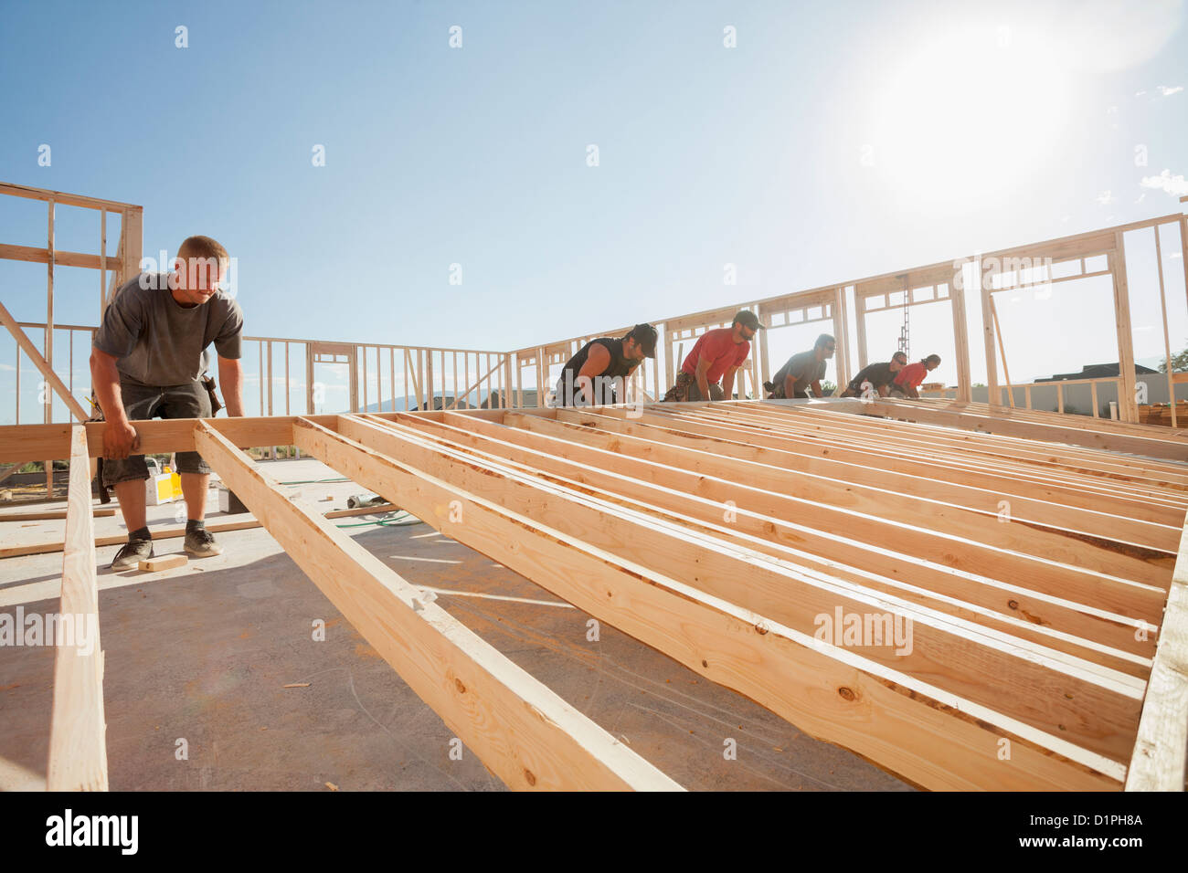 Workers lifting frame on construction site Stock Photo - Alamy
