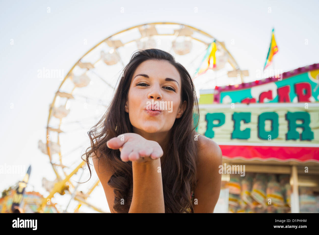 Caucasian woman at carnival blowing a kiss Stock Photo - Alamy
