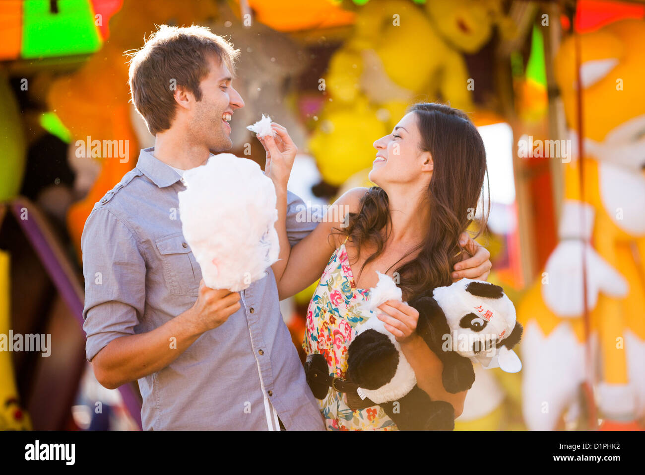 Caucasian couple sharing cotton candy at carnival Stock Photo - Alamy