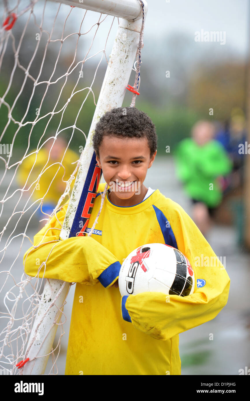 A school boy carrying a football goal at the end of a rained off ...