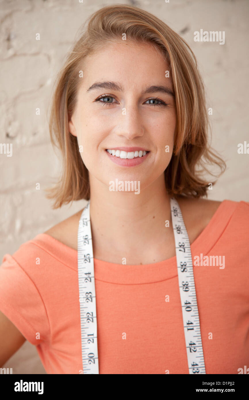 Caucasian woman with measuring tape around her neck Stock Photo - Alamy