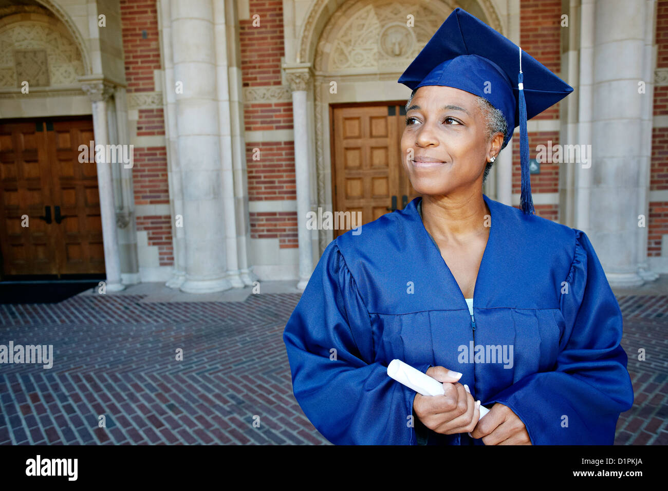 Smiling Black woman holding graduation diploma Stock Photo - Alamy
