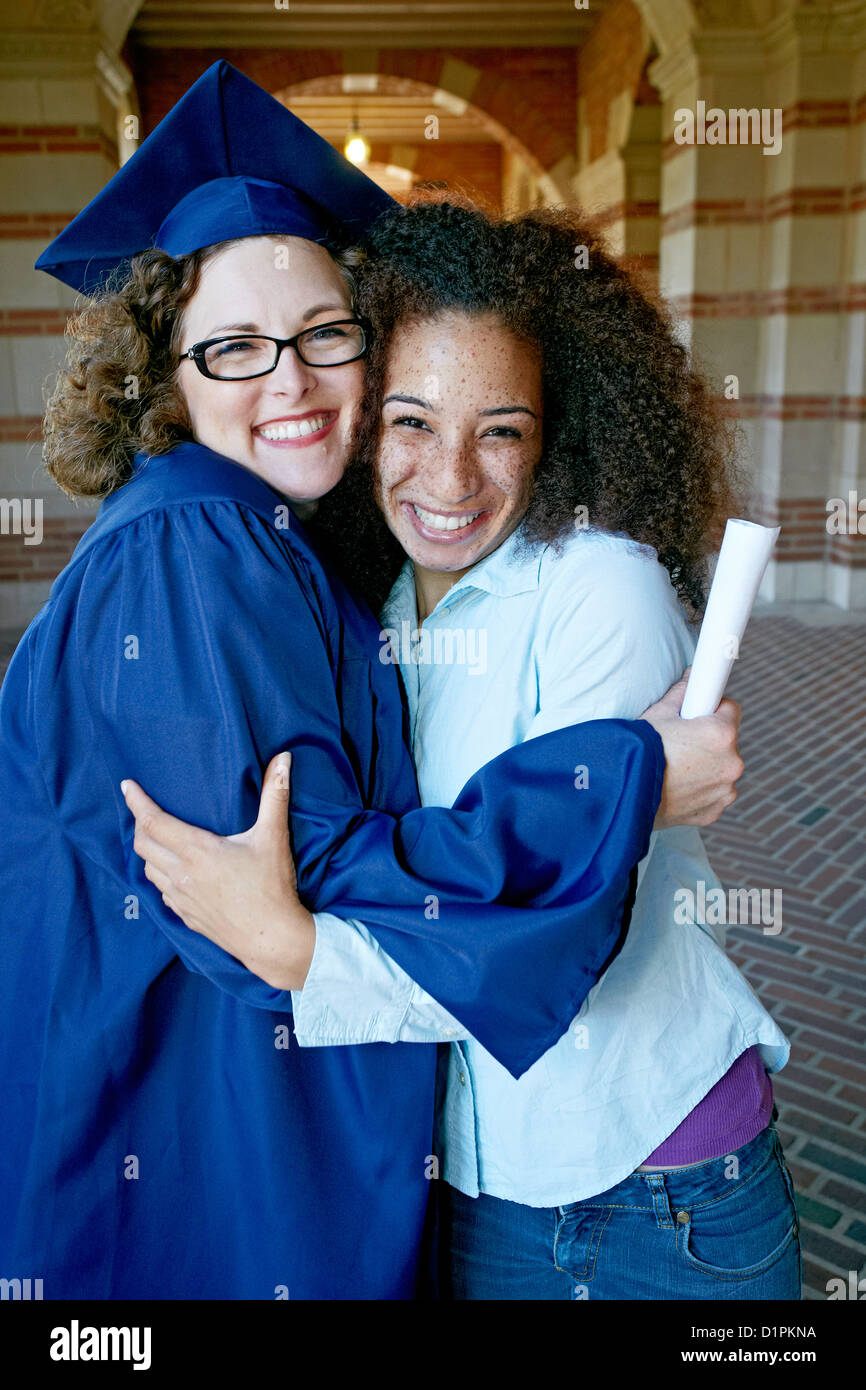Friend hugging graduate Stock Photo - Alamy