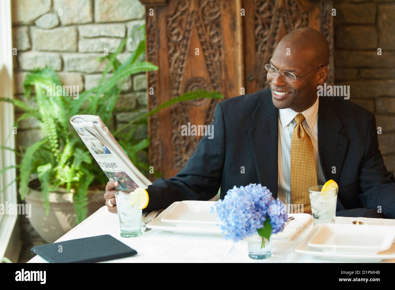 Black businessman reading newspaper in restaurant Stock Photo - Alamy