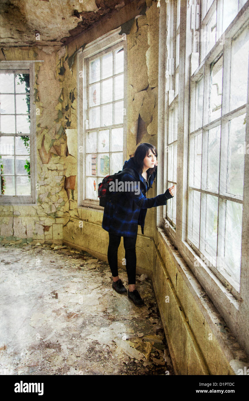Scared woman looking out of a window Stock Photo - Alamy