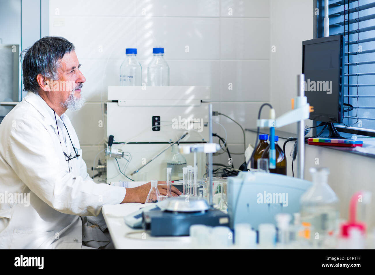 Senior male researcher carrying out scientific research in a lab ...