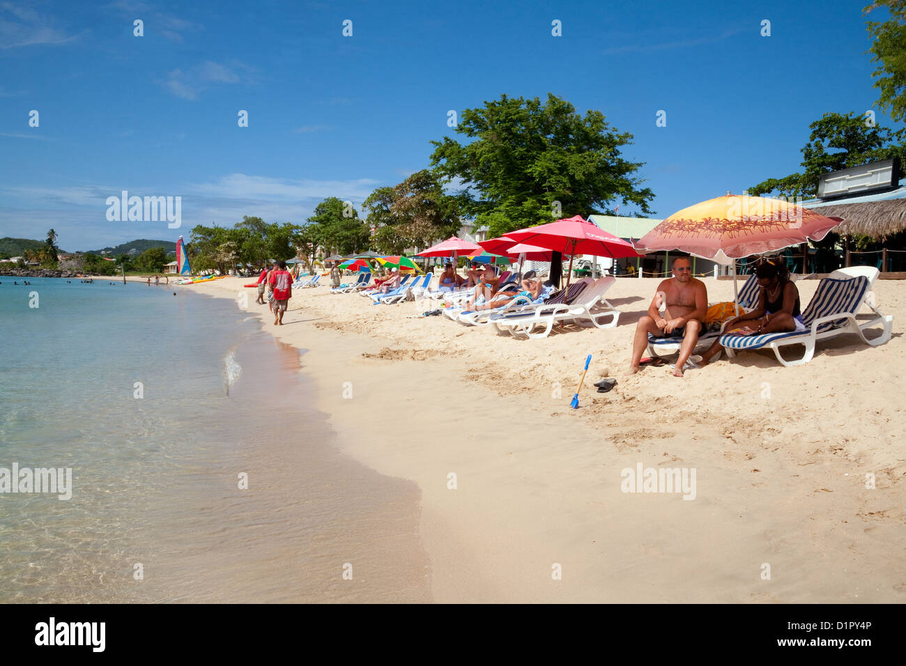Tourists sunbathing on Reduit Beach, St Lucia, caribbean, West Indies ...