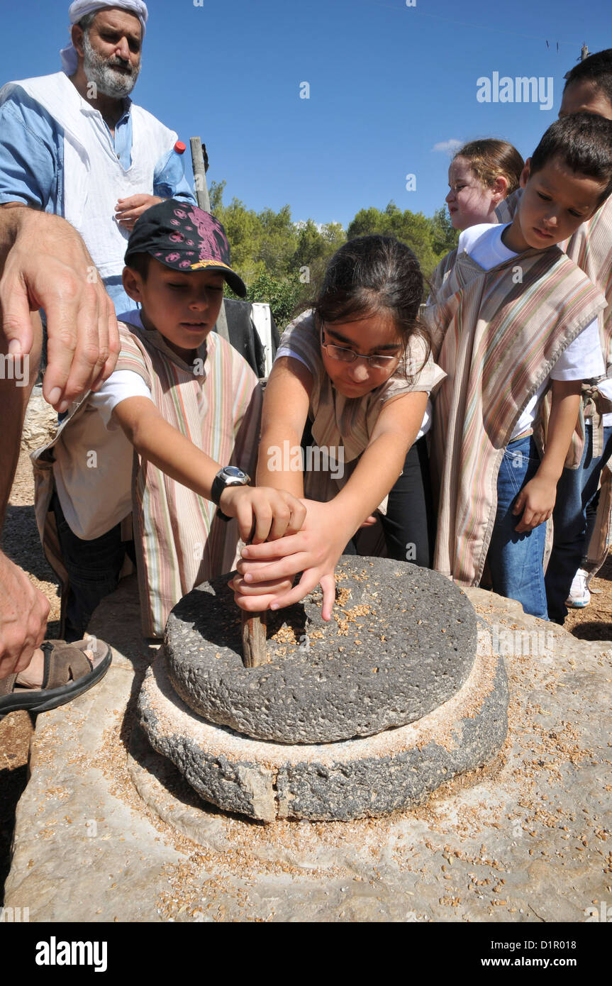 Children experience hand operated millstone hi-res stock photography ...
