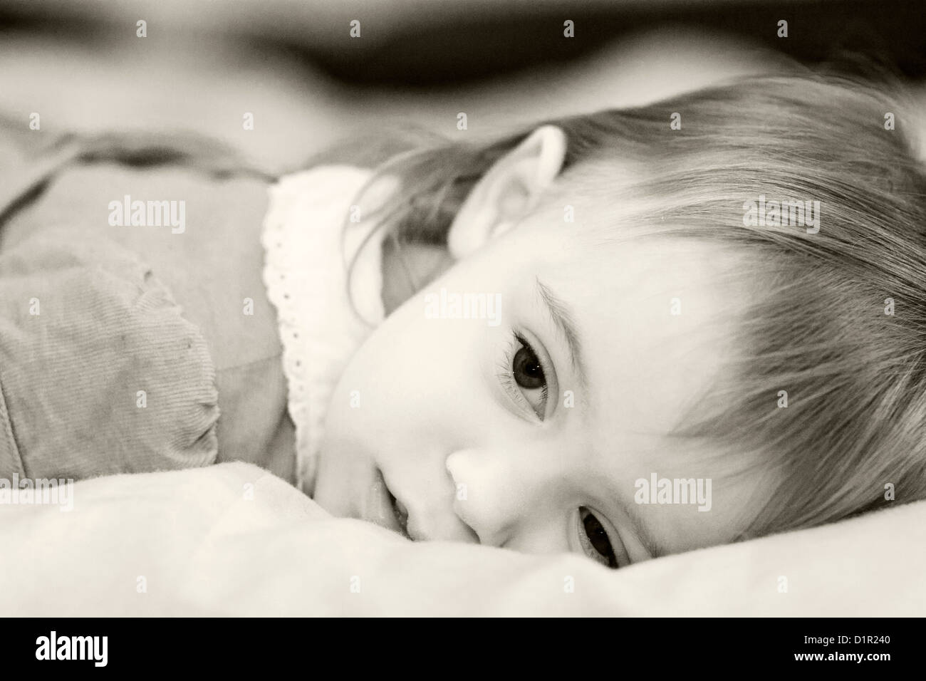 Toddler laying on bed Stock Photo - Alamy