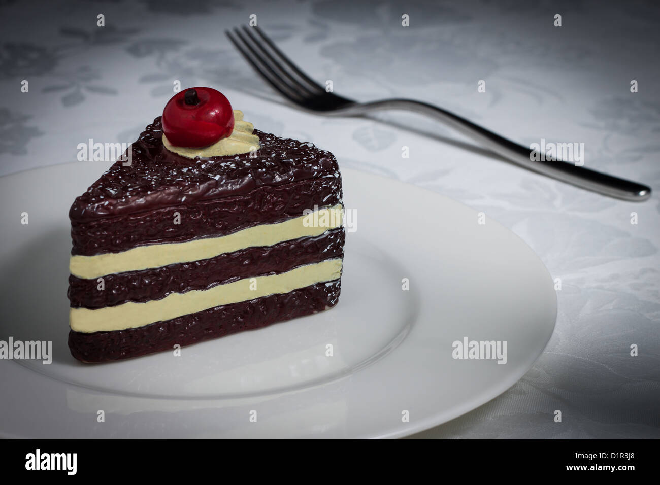 Fake slice of cake in a dish with steel fork Stock Photo - Alamy