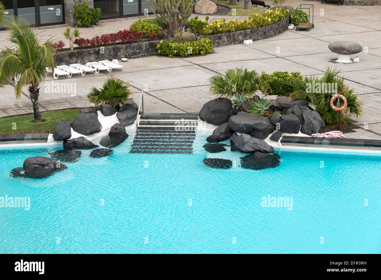 swimming pool with blue water and big rocks Stock Photo - Alamy