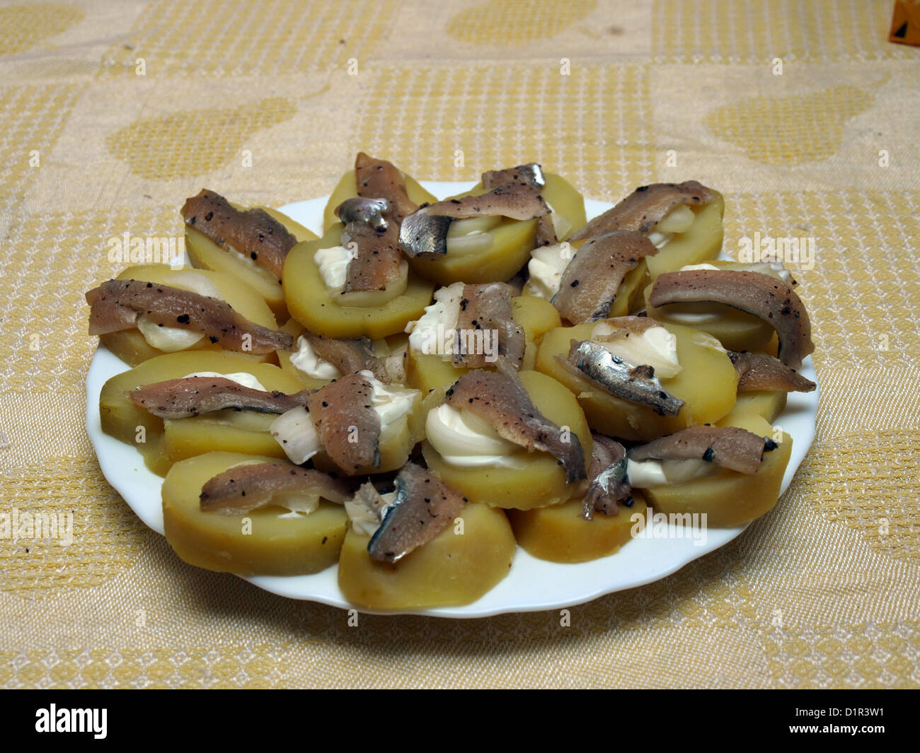 Anchovy potato slices with onion and mayonnaise, on white dish Stock ...