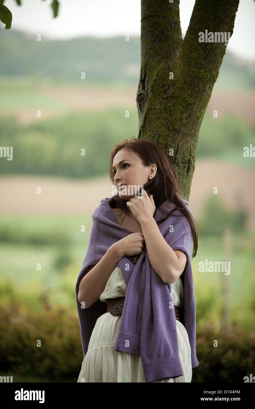 woman leaning against a tree in the countryside Stock Photo - Alamy