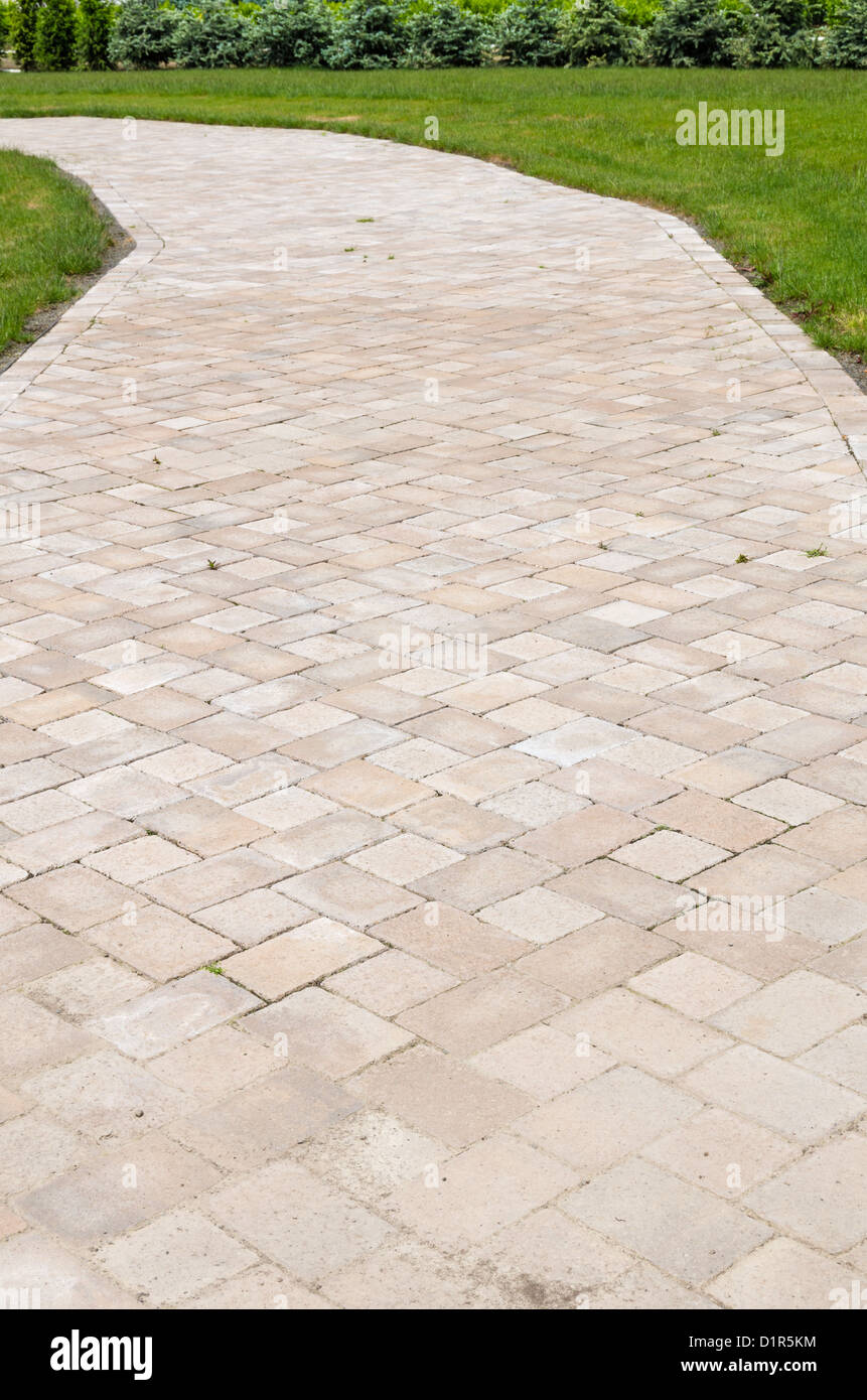 A paved walkway with green grass Stock Photo - Alamy