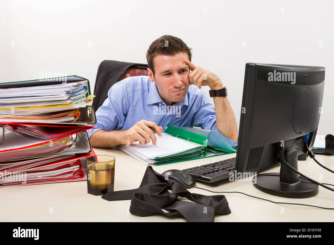 Confused accountant looking at some info on the display of his computer ...