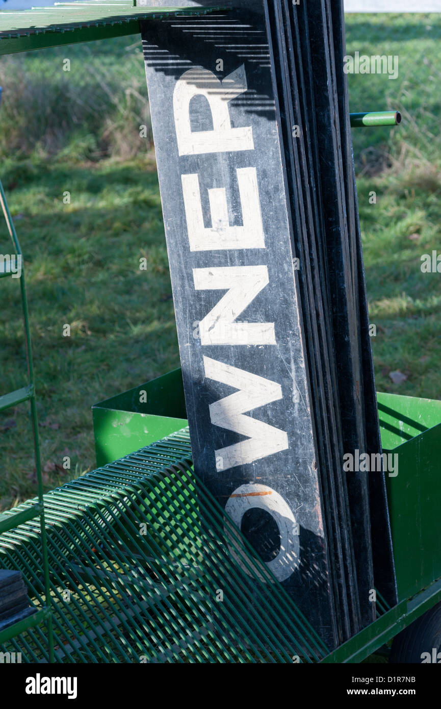 A sign with the word owner on it in a rack at Cottenham Point to point ...