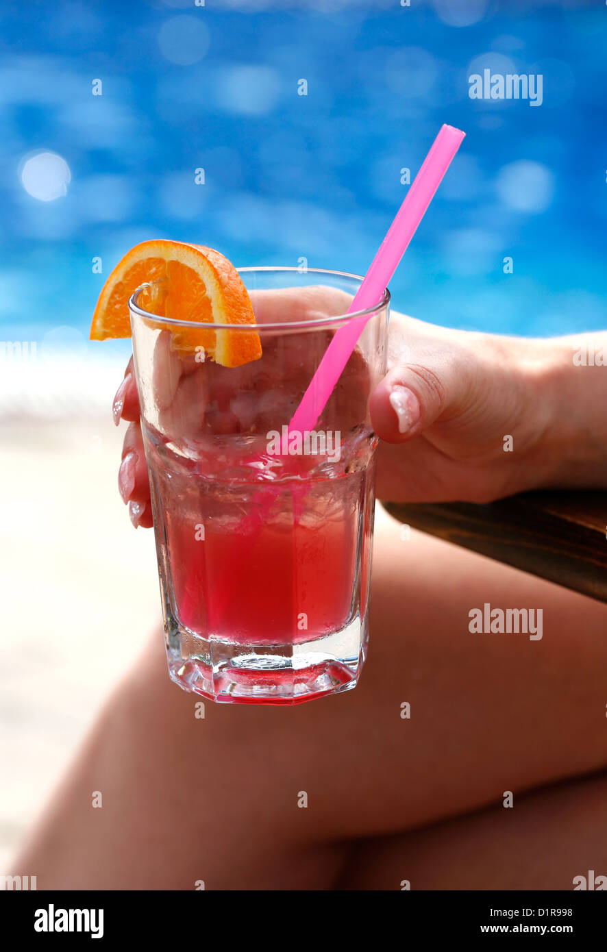 Female hand about a cocktail with an orange Stock Photo - Alamy