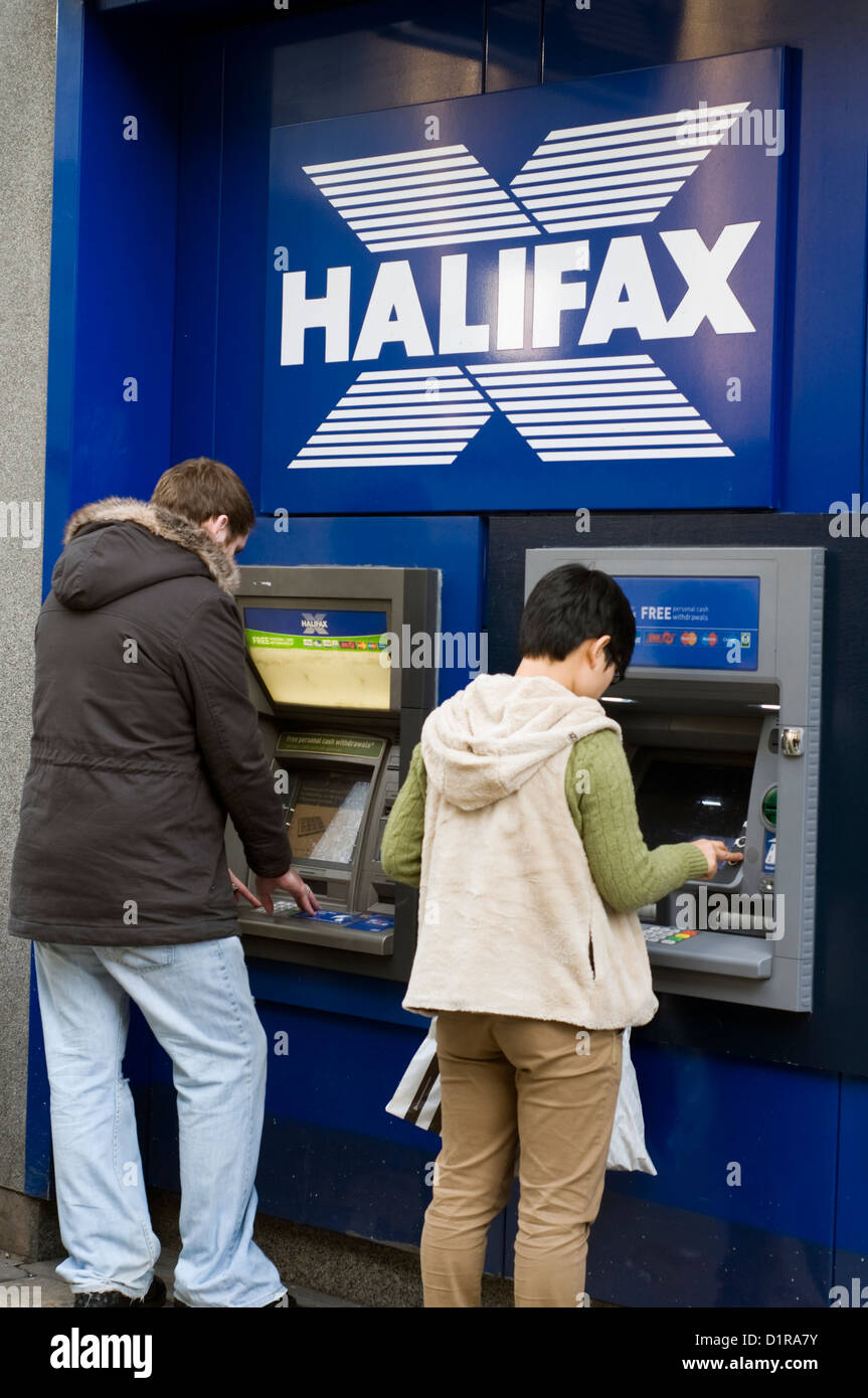 People withdrawing money from a Halifax Bank cash machine Stock Photo ...