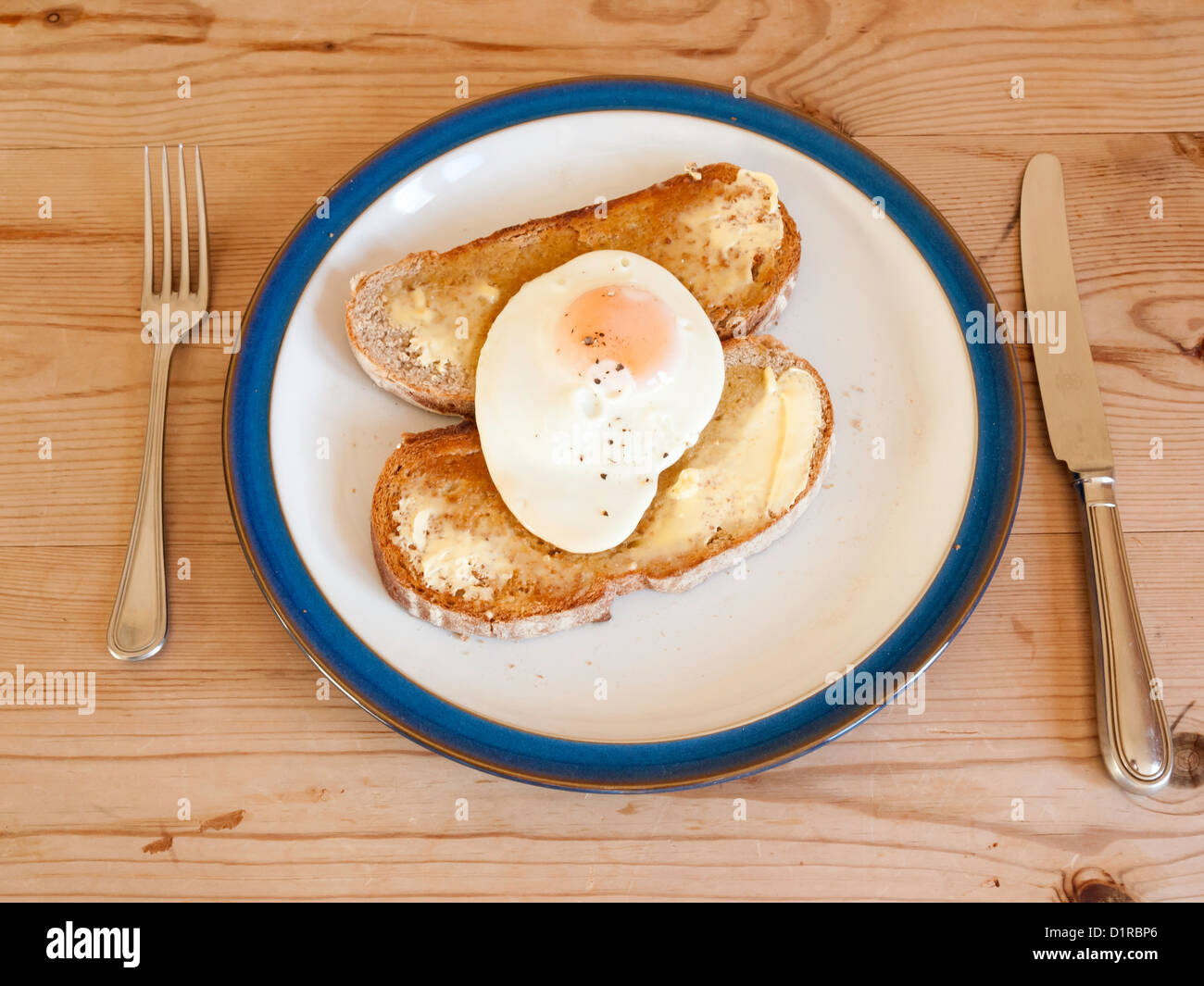 A fried egg on two slices of buttered toasted Rye Bread ready to eat ...