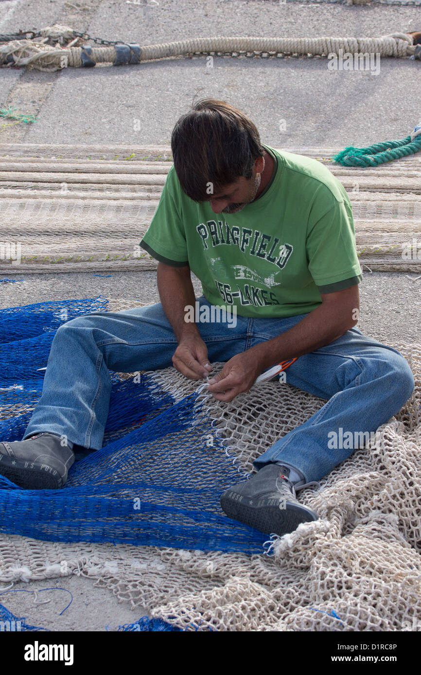 A fisherman mending his nets Stock Photo - Alamy