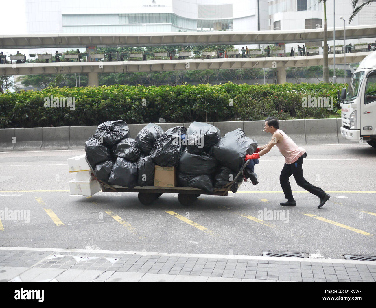Asian male worker pushing garbage trash Stock Photo - Alamy