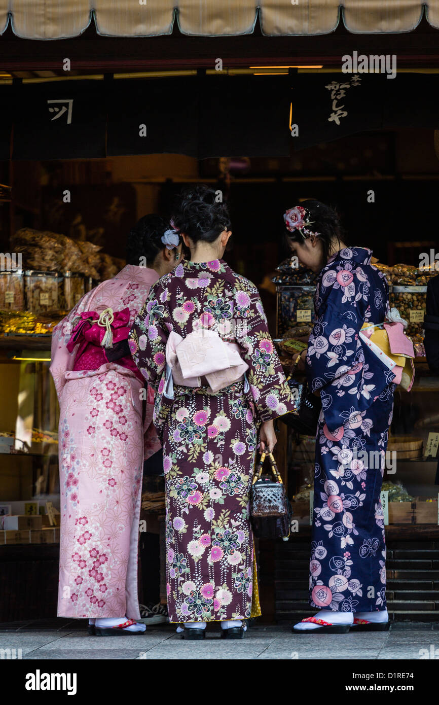 Three women dressed in traditional clothing go shopping before the ...