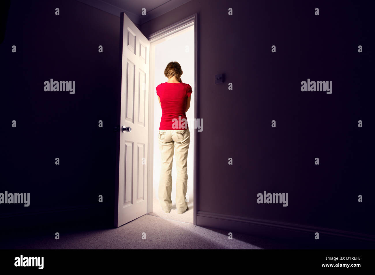 Woman standing behind door hi-res stock photography and images - Alamy