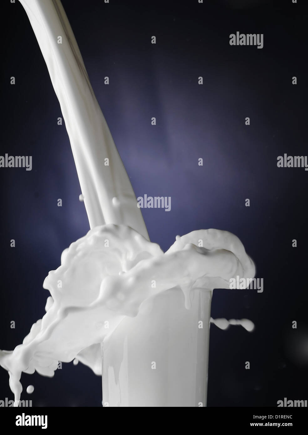 Milk splashing while being poured in a glass Stock Photo - Alamy