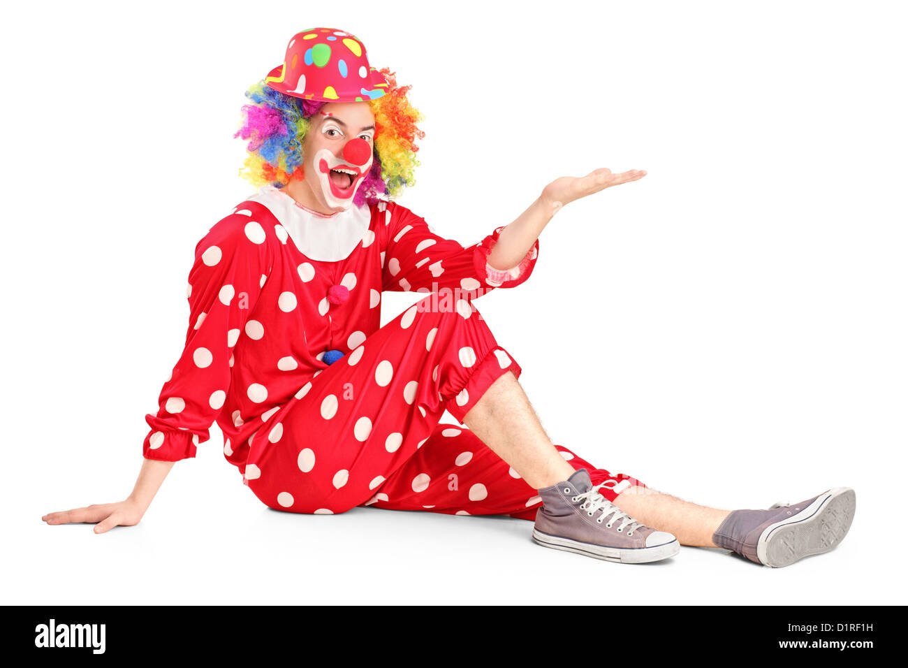 A clown with smiling joyful expression sitting down and gesturing ...