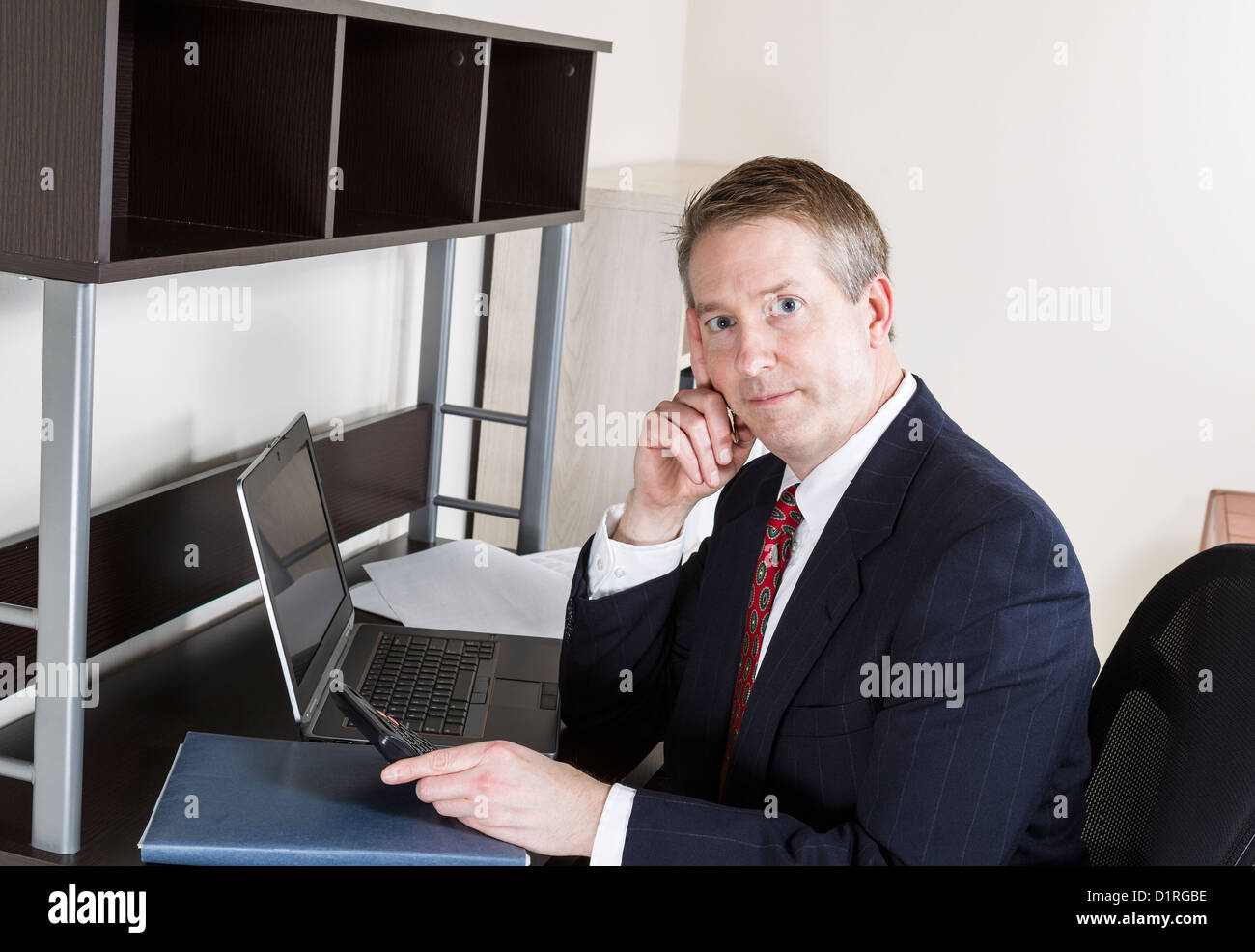 Mature man with index finger along side of head while holding ...