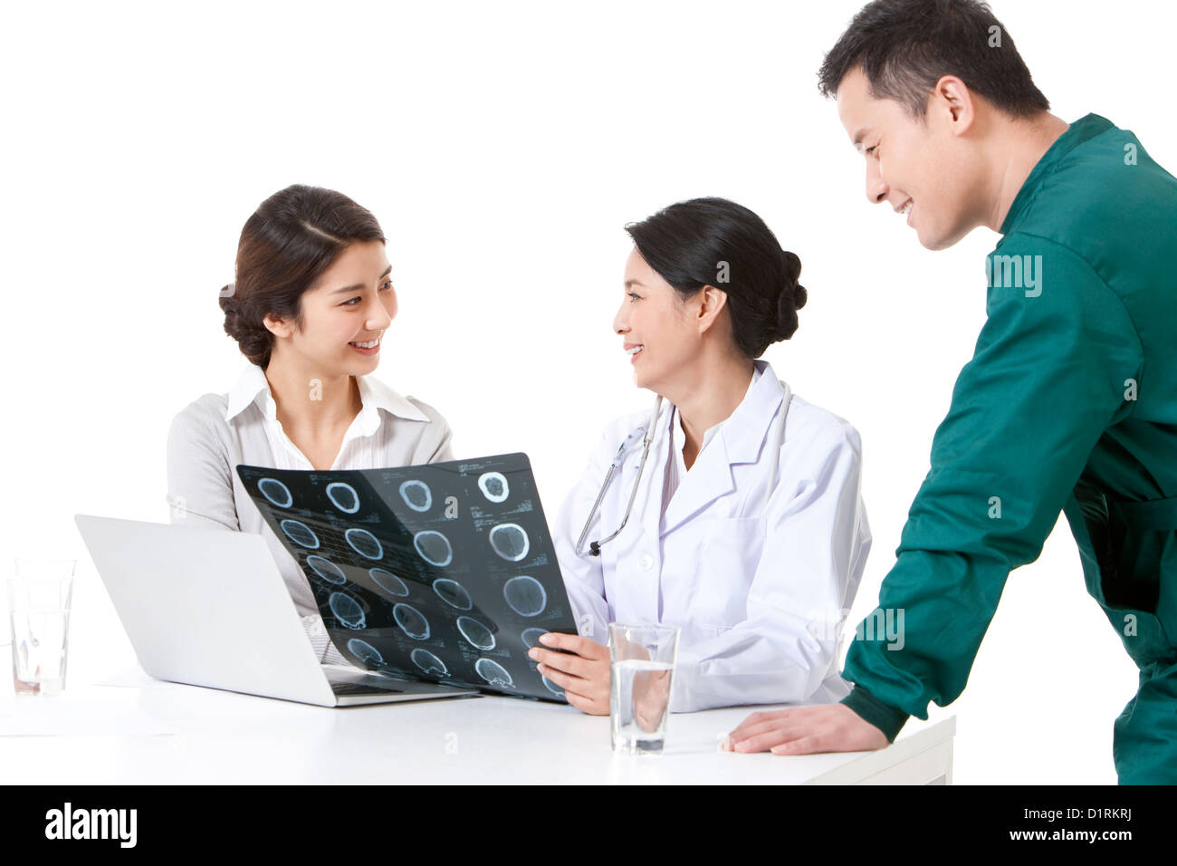 Professional doctors checking X-ray image with young woman Stock Photo ...