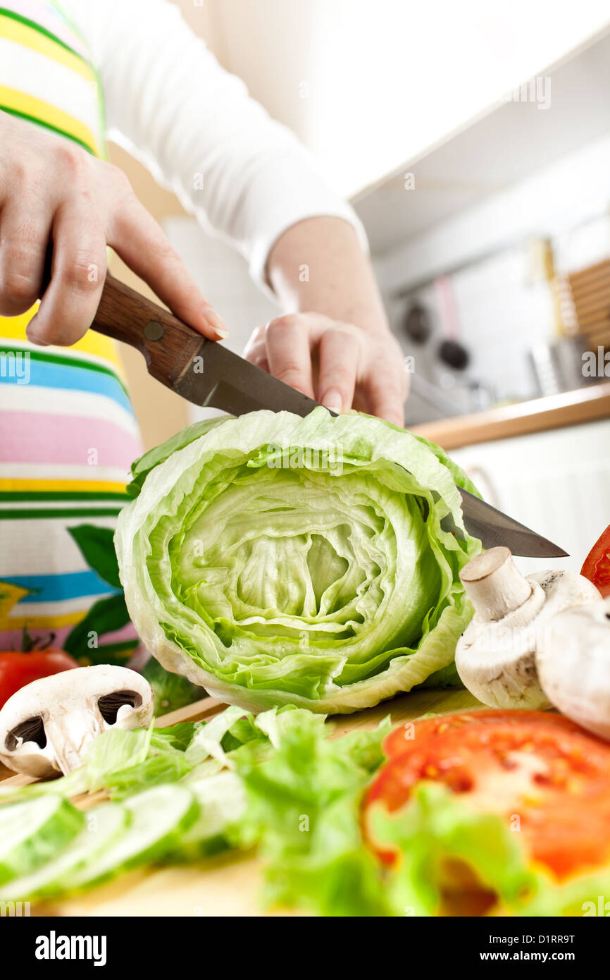 Woman's hands cutting lettuce, behind fresh vegetables Stock Photo - Alamy