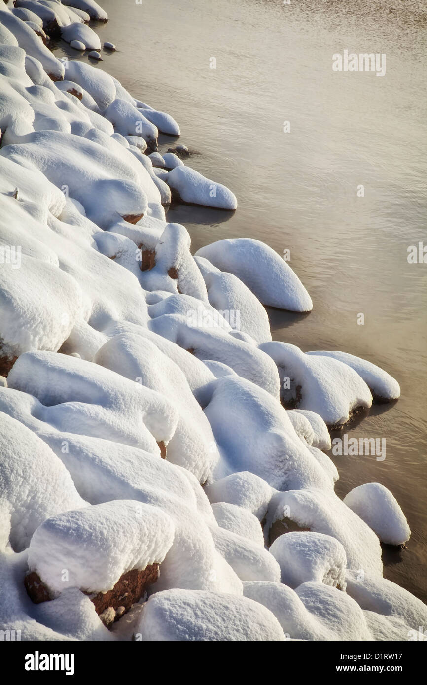 Large rocks along a shoreline covered in snow Stock Photo - Alamy