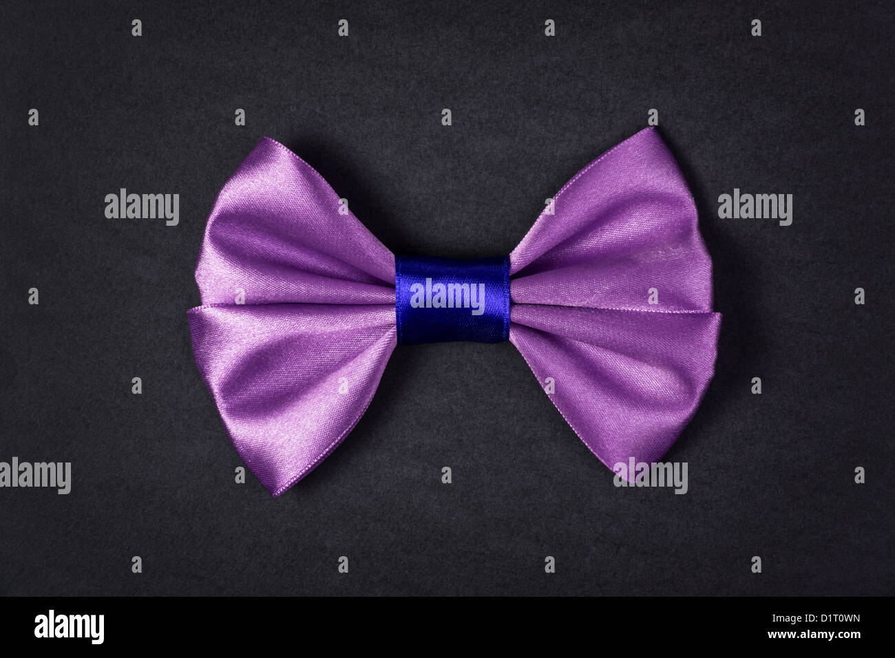 purple ribbon bow on black paper background Stock Photo - Alamy