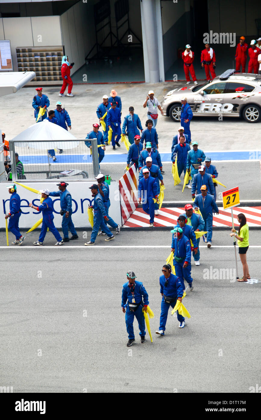 Technical teams march out into the race track of Sepang International ...