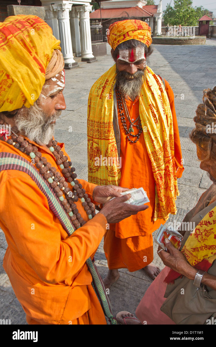 Sadhu holy men counting money at the burning ghats at Pashupatinath ...