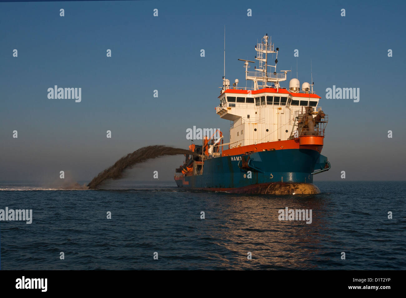 Trailing suction hopper dredger depositing material on artificial beach ...