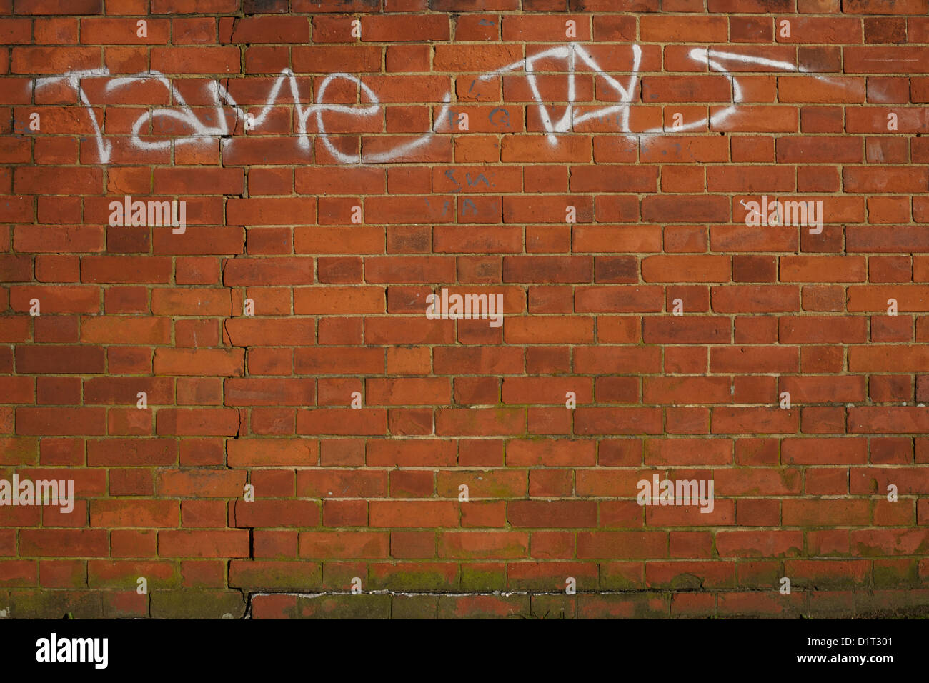 Graffiti tag on red brick wall in white paint Stock Photo - Alamy