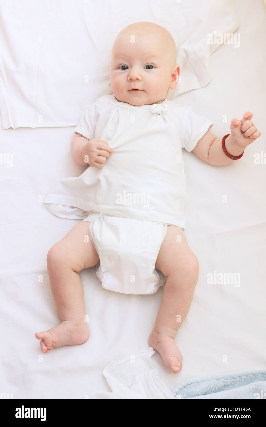Cute three-month baby girl lying in bed and looking at the camera Stock Photo - Alamy