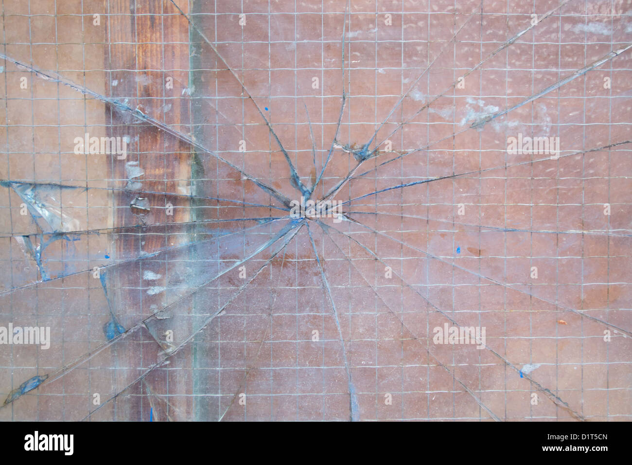 broken safety glass with cracks radiating outwards in a spiders web ...