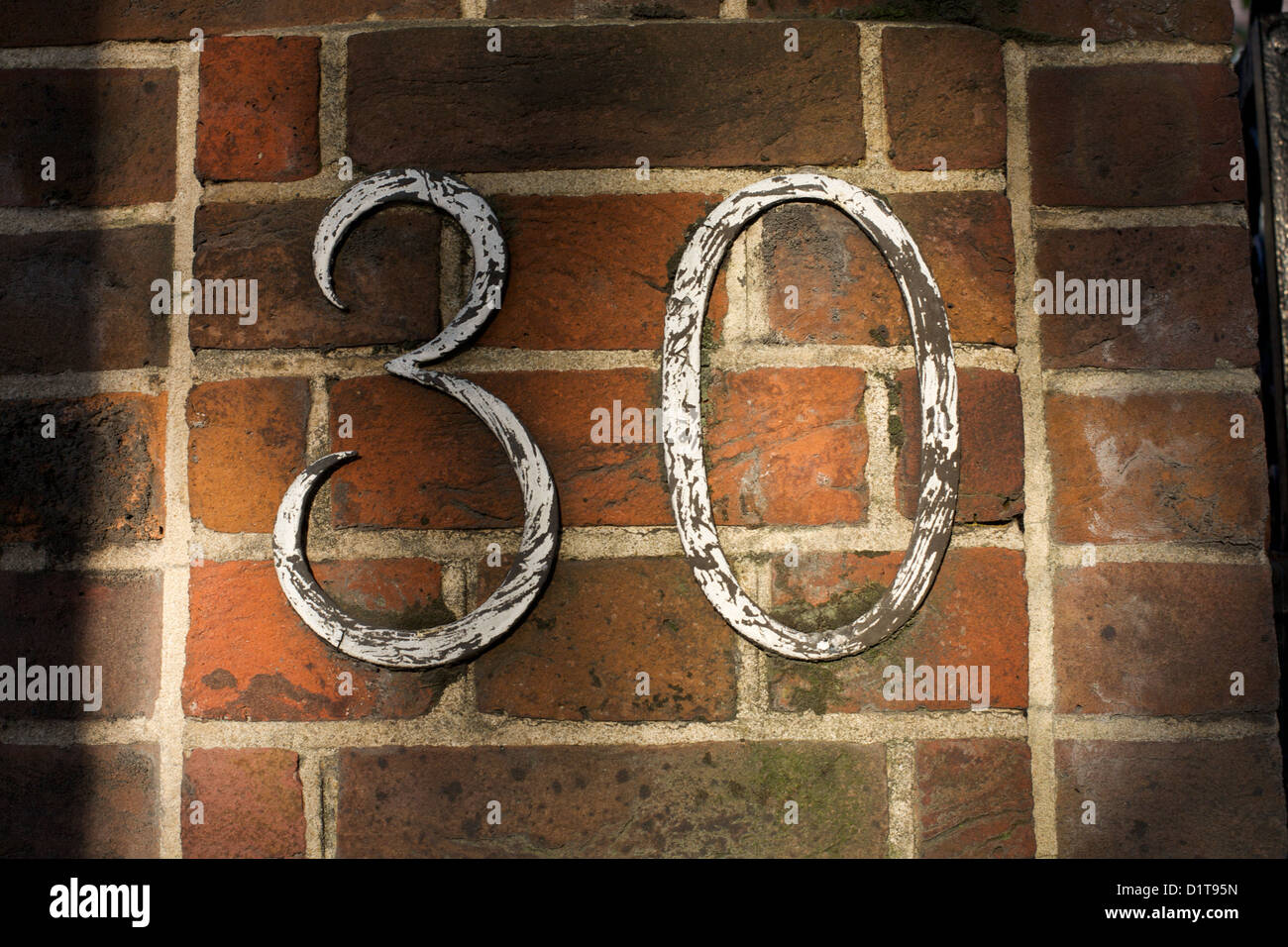 The number 30 for a house address on a brick wall Stock Photo - Alamy