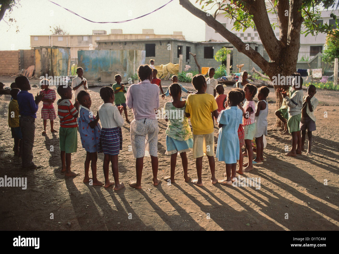Children singing in a circle outside a primary school in a village in ...