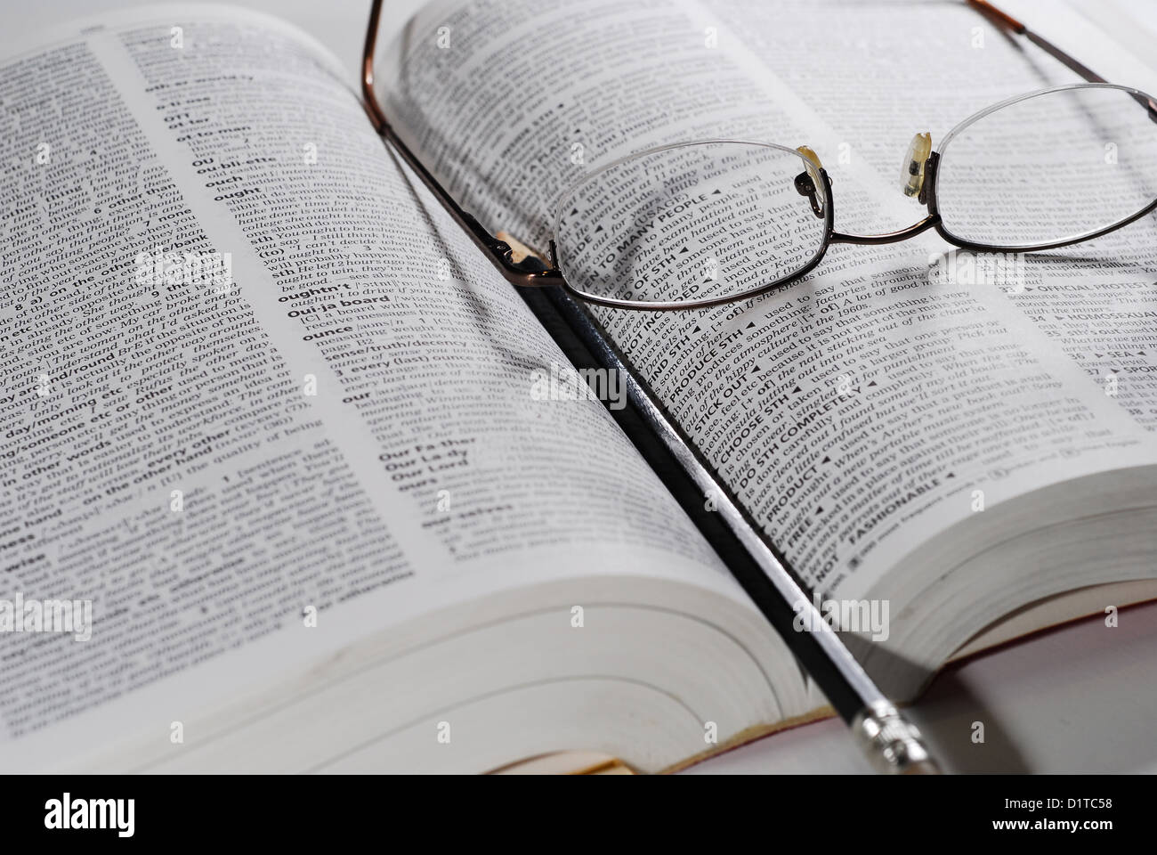 closeup of open book, reading glasses and pencil Stock Photo - Alamy
