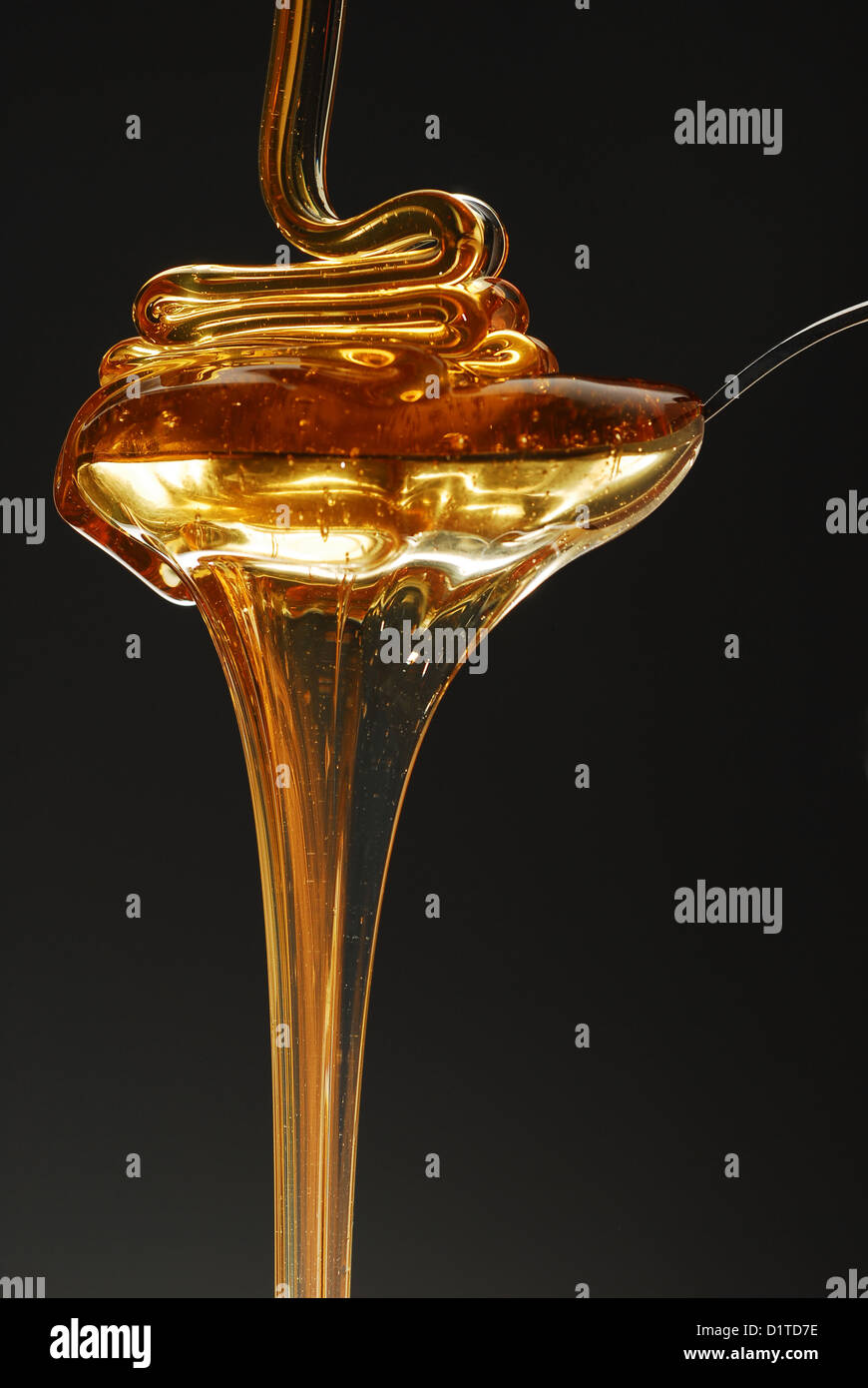 Sweet honey spilling over the spoon stock photo Stock Photo - Alamy
